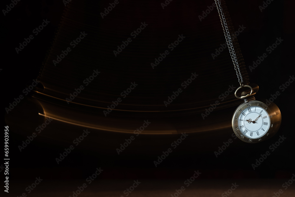 Hypnosis session. Vintage pocket watch with chain swinging over surface ...