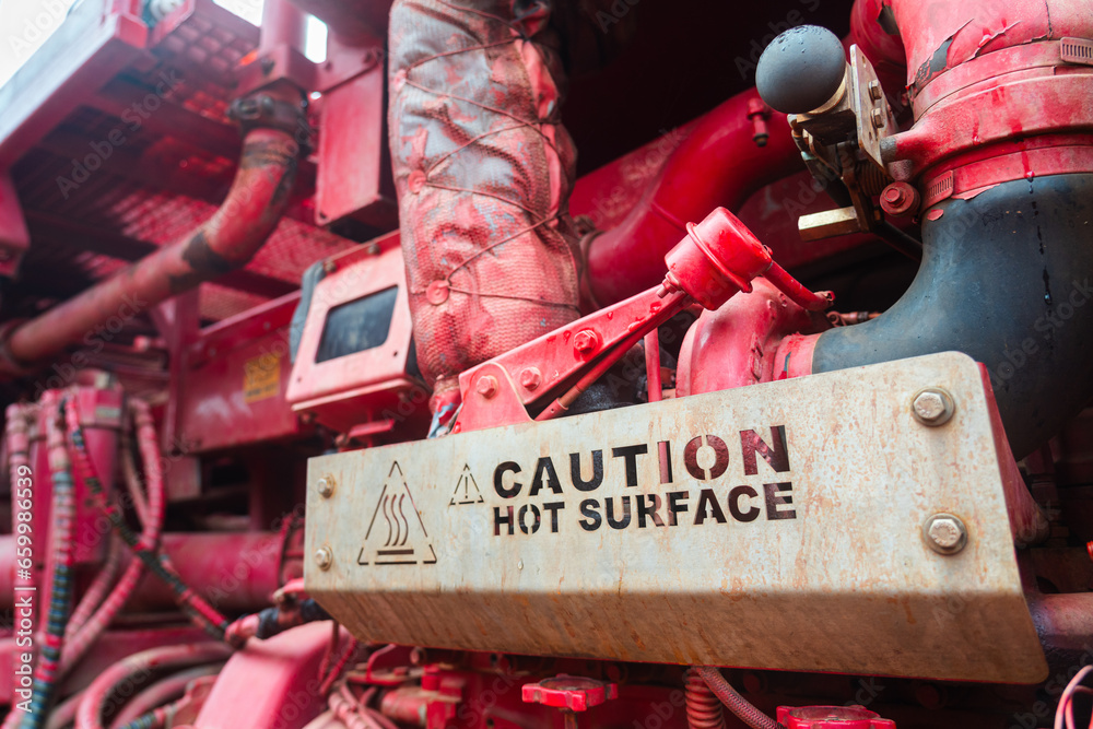 Steel plate "Hot surface" caution sign on the heavy pumping unit ...