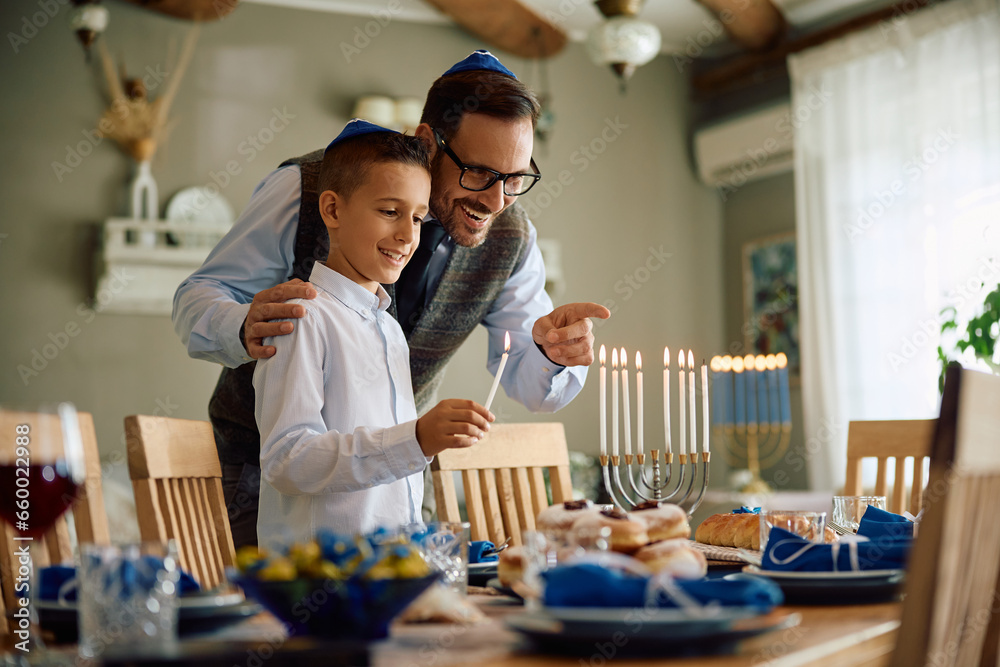 Happy Jewish father and son lighting menorah on Hanukkah. Stock Photo ...