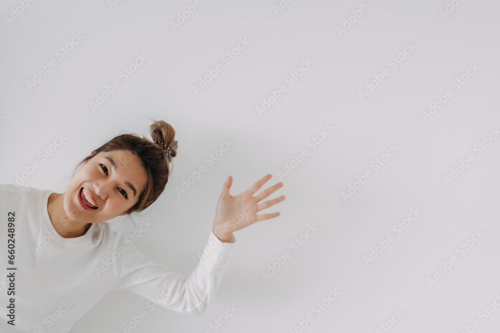 Happy Thai Asian woman bun hair, waving both hands gesture to say hello ...
