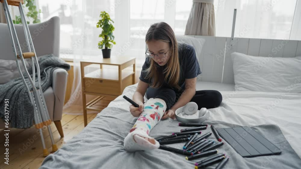 Teenage girl after injury with broken leg in orthopedic cast painting ...