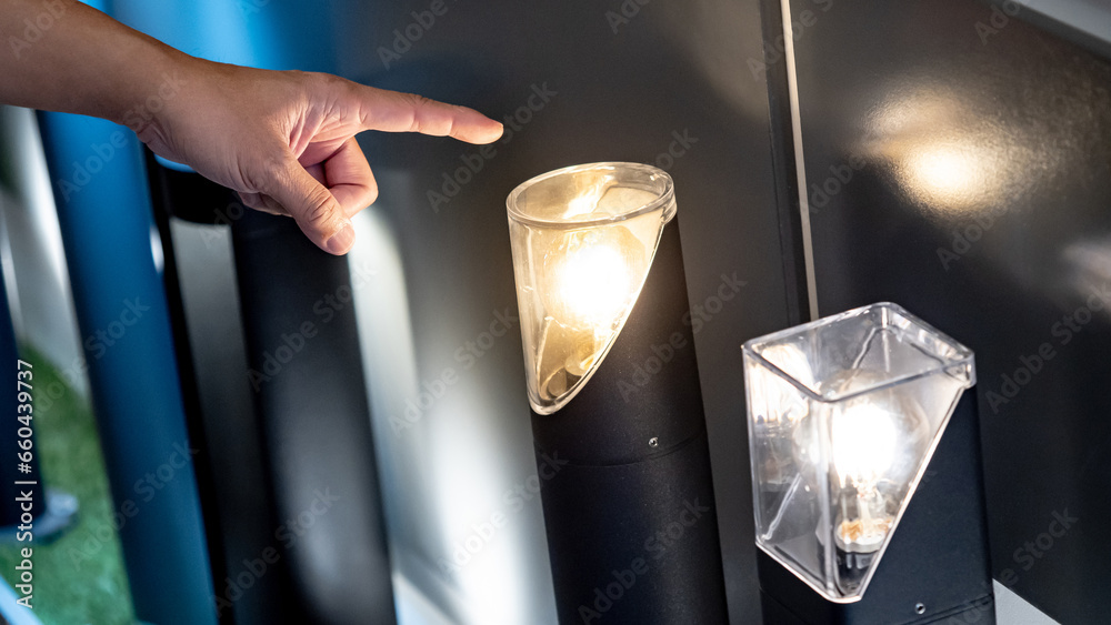 Foto de Designer hand pointing at sample of outdoor solar bollard ...