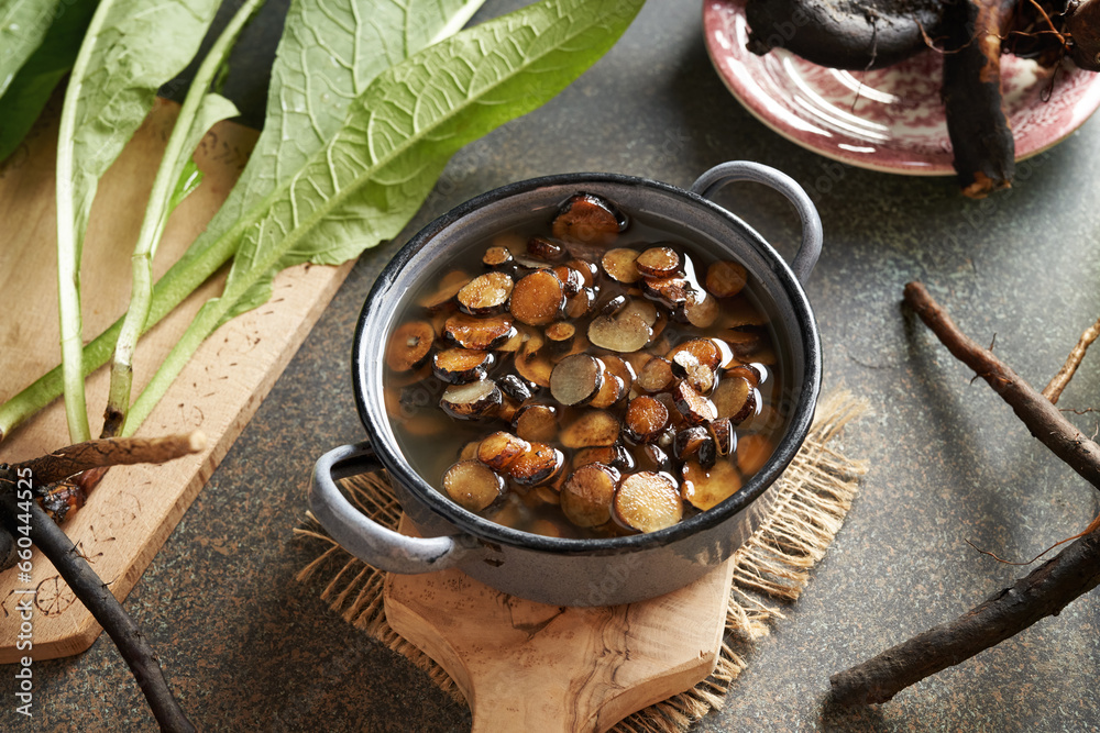 Preparation of comfrey root ointment from rendered pork lard and fresh ...