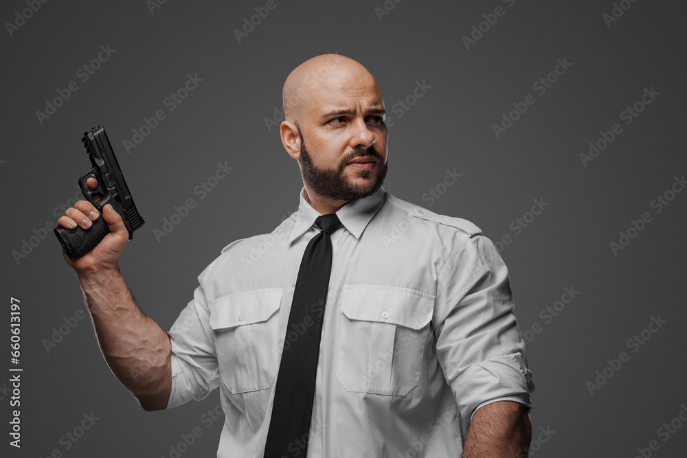 Bald, bearded man in white shirt and tie holds a pistol, epitomizing a ...