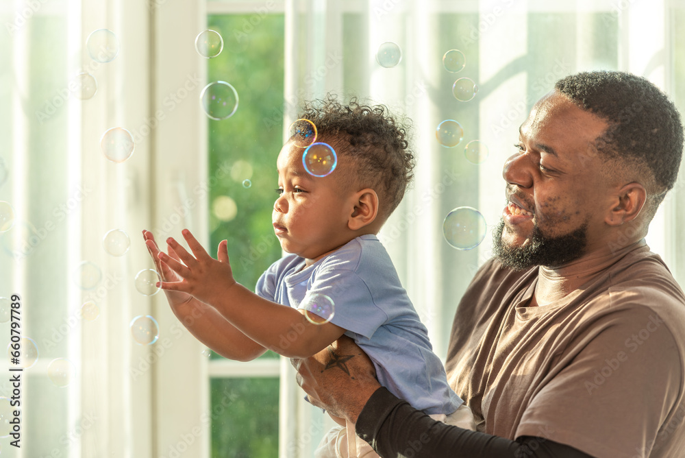 Happy african black parents dad father throw baby son on piggyback and ...