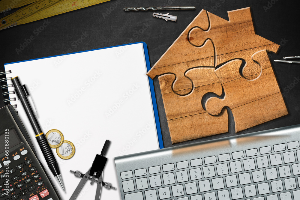 Small wooden model house made of jigsaw puzzle pieces on a desk with ...