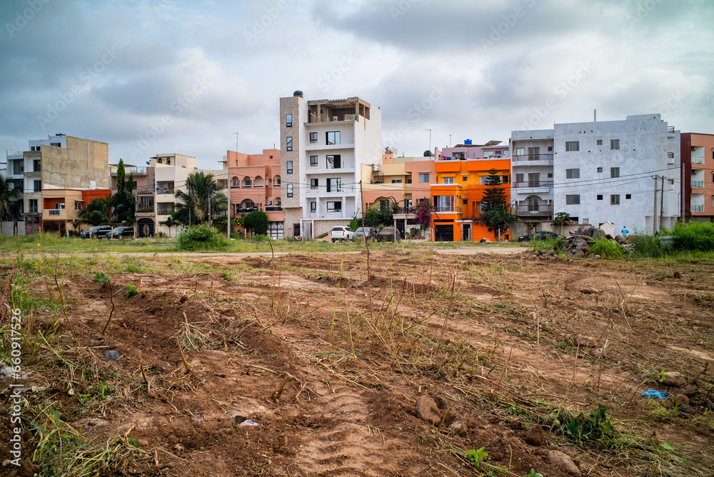 Un terrain vague avec des immeubles en construction au fond vers l ...