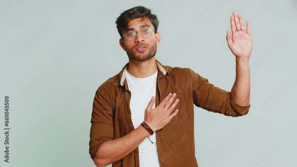 I swear to be honest. Sincere responsible Indian man raising hand to ...