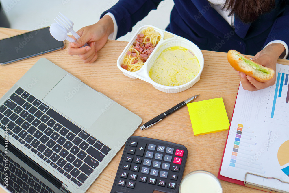 Female employee working in the office, rush job She works and eats at ...