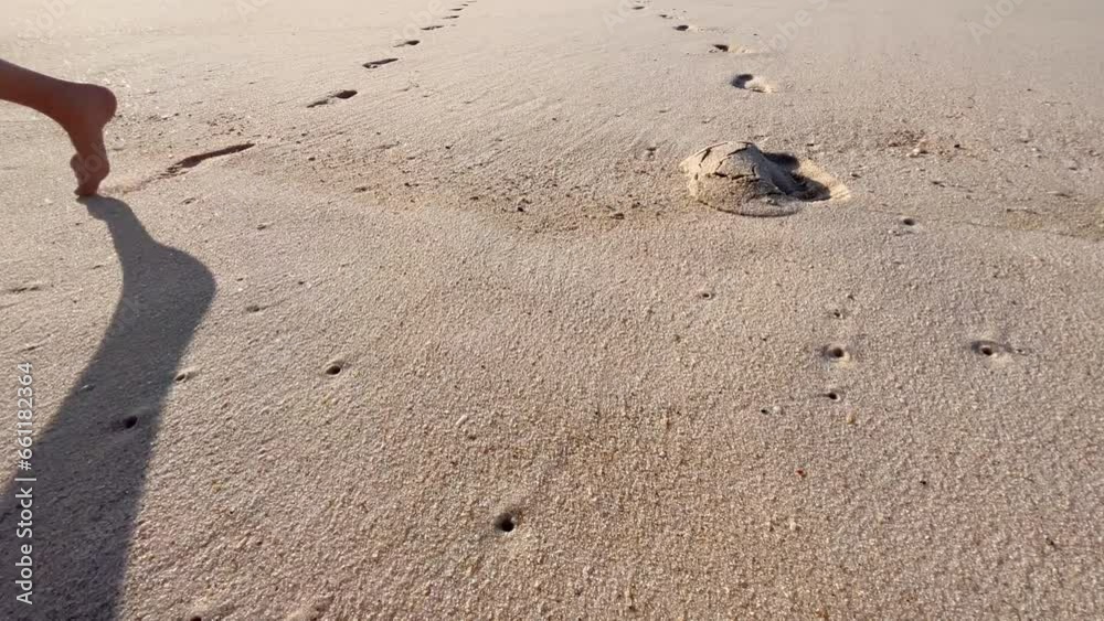 Two children run on the beach. Close up view on running legs ...