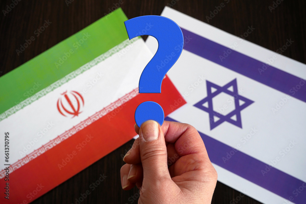 hands hold the question mark against the background of the flags of ...