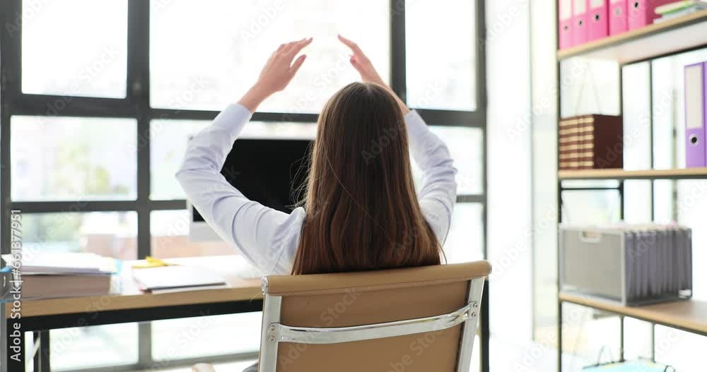 Rear view of female manager resting in office chair at workplace ...
