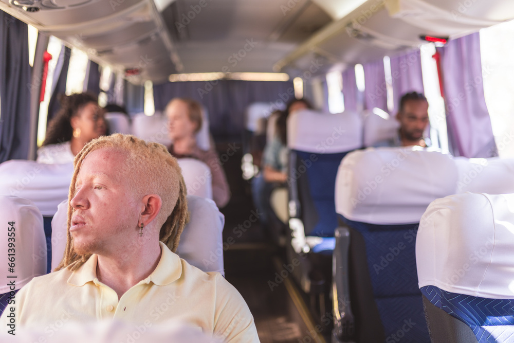 Albino man with dreadlocks sitting on the bus looking at the window ...