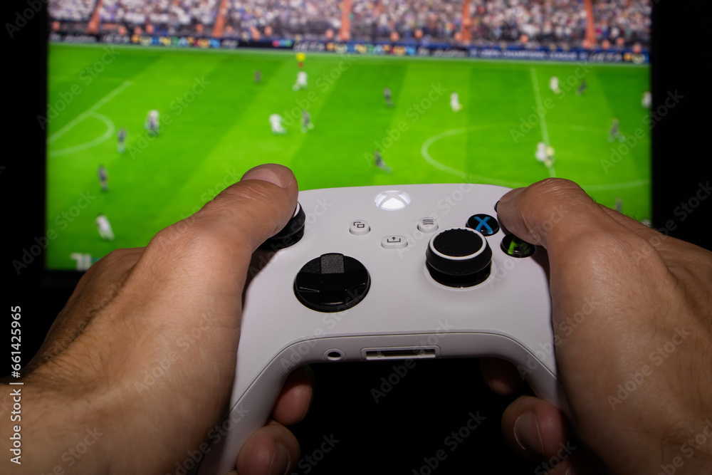 Dnipro, Ukraine, 28 september 2023: Man playing EA FC 24 with Xbox controller on TV screen Stock ...