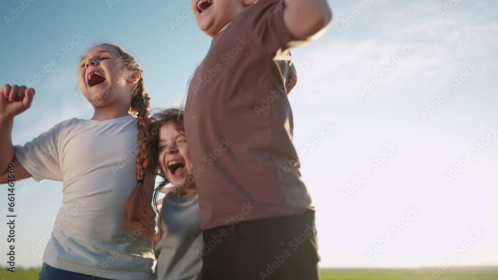 group of kids team hugging a jumping and rejoicing outdoors. happy ...
