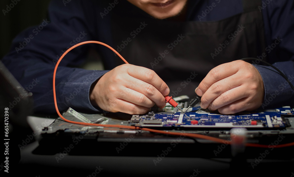 young man who is a computer technician A laptop motherboard repairman ...