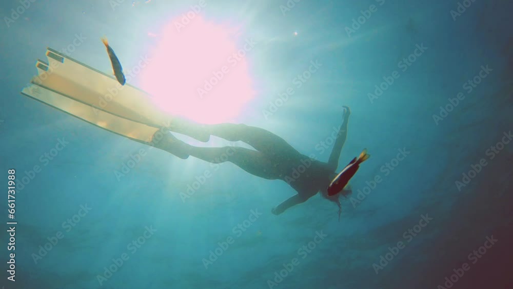 bottom to top view of a young asian free diver wearing long fins and ...