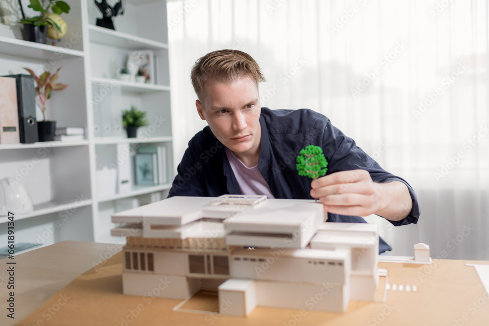 Architect designer studies elegant house model, reviewing structure ...