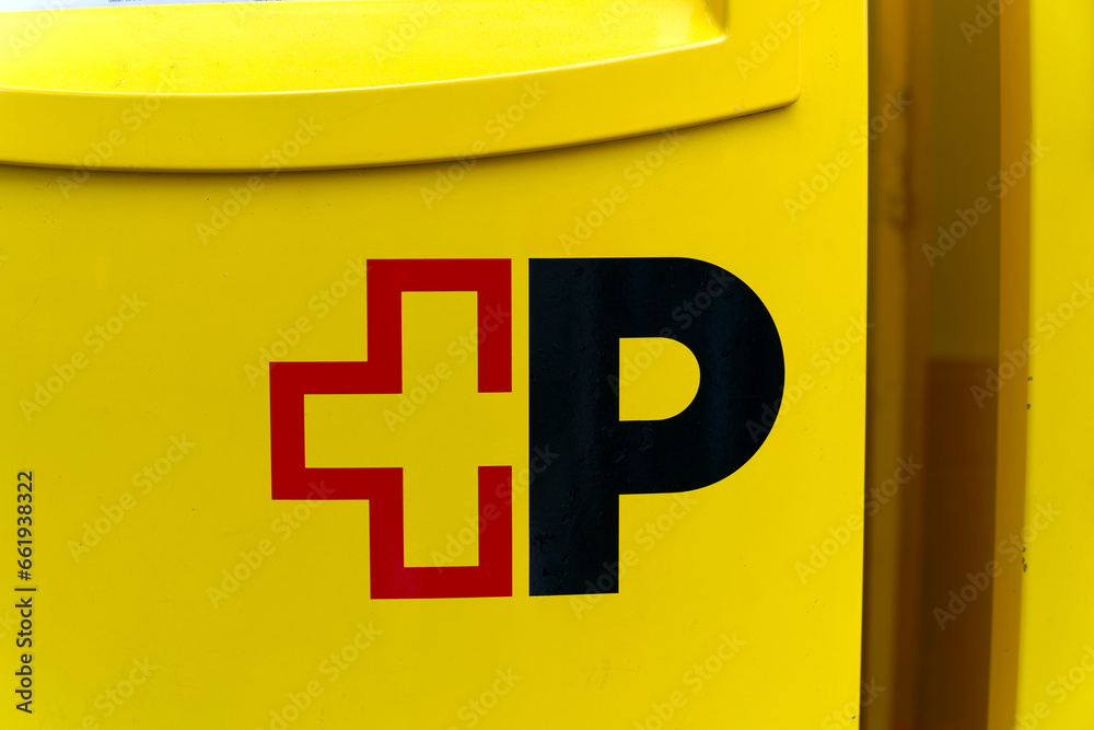 Yellow letter box in front of post office with new logo of Swiss Post ...