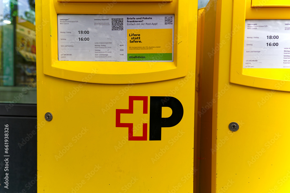 Yellow letter box in front of post office with new logo of Swiss Post ...