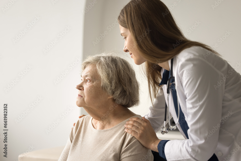 Caring therapist touch shoulders of upset old woman looking away, give ...