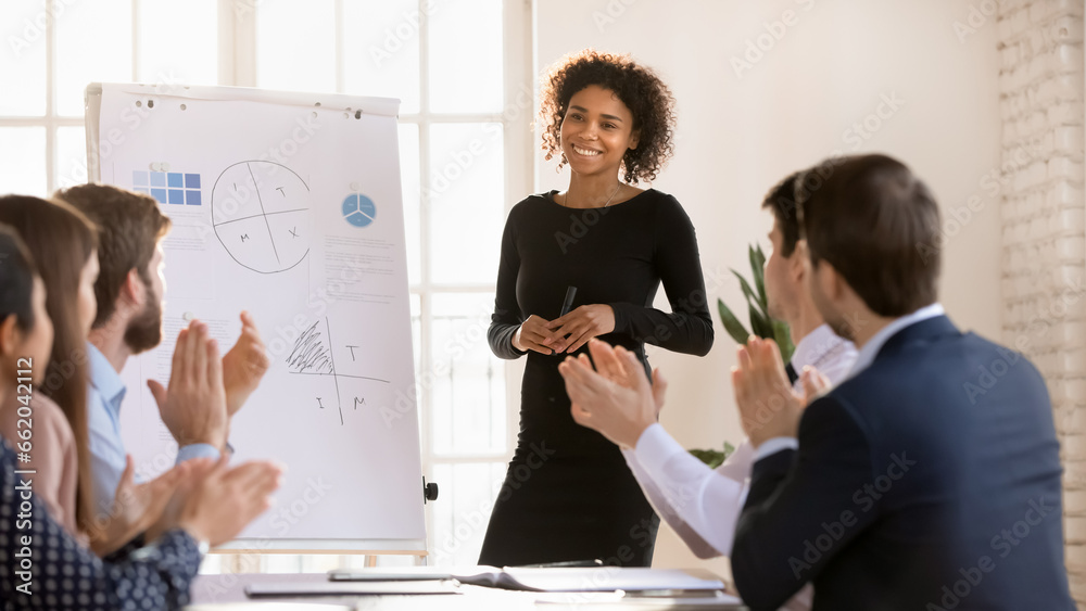 Diverse team of employees applauding to positive successful speaker ...