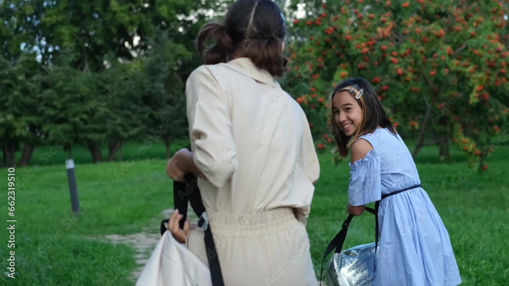 Two girls fight with school backpacks and laugh cheerfully in the ...