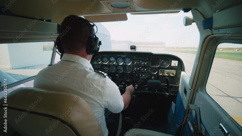 The pilot in the cockpit starts the engine of the small plane, and ...