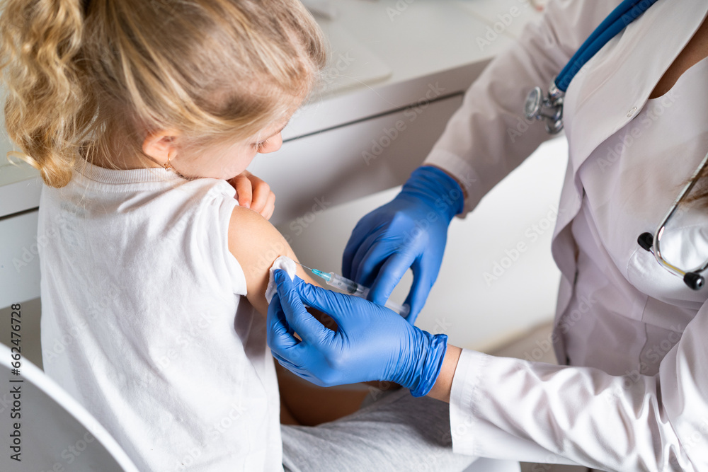 vaccination of children, a little girl at a doctor's appointment, an ...