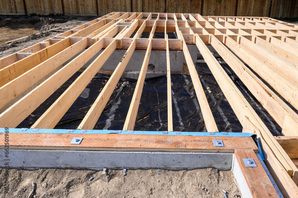 Beginnings of a new home, wood floor joists installed over concrete ...