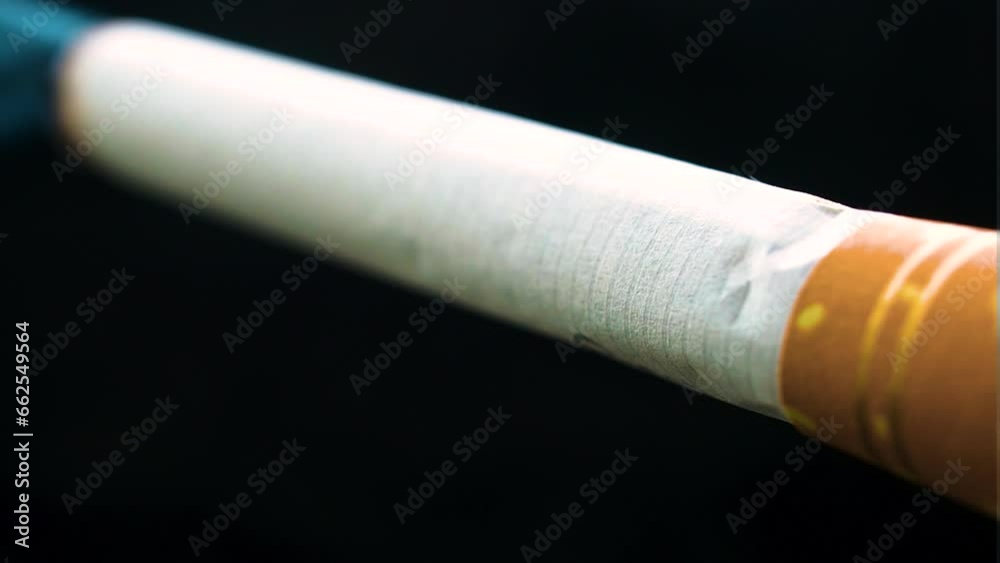 full fresh cigarette is lighten up by the lighter and left to be burned ...