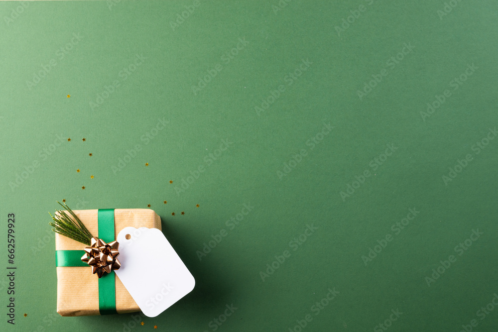 Christmas presents with green ribbon and tag with copy space on green ...
