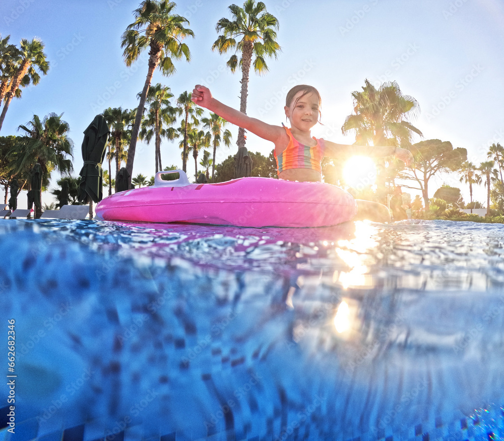 Girl floats on pink inflatable in the pool. Beach resort vacation by ...