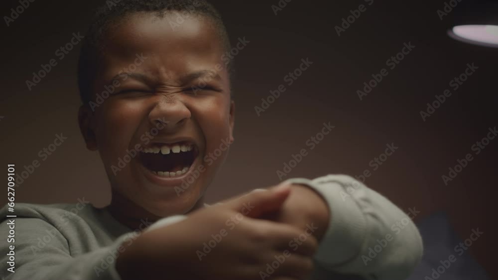 Medium closeup of frightened African American little boy screaming out ...