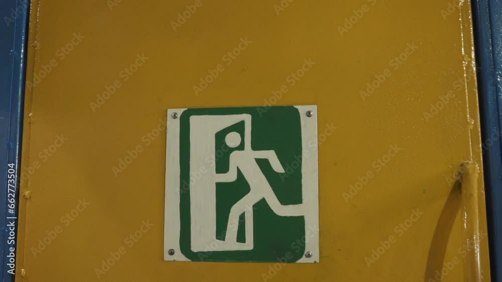 Green sign for direction of exit from premises during evacuation on ...