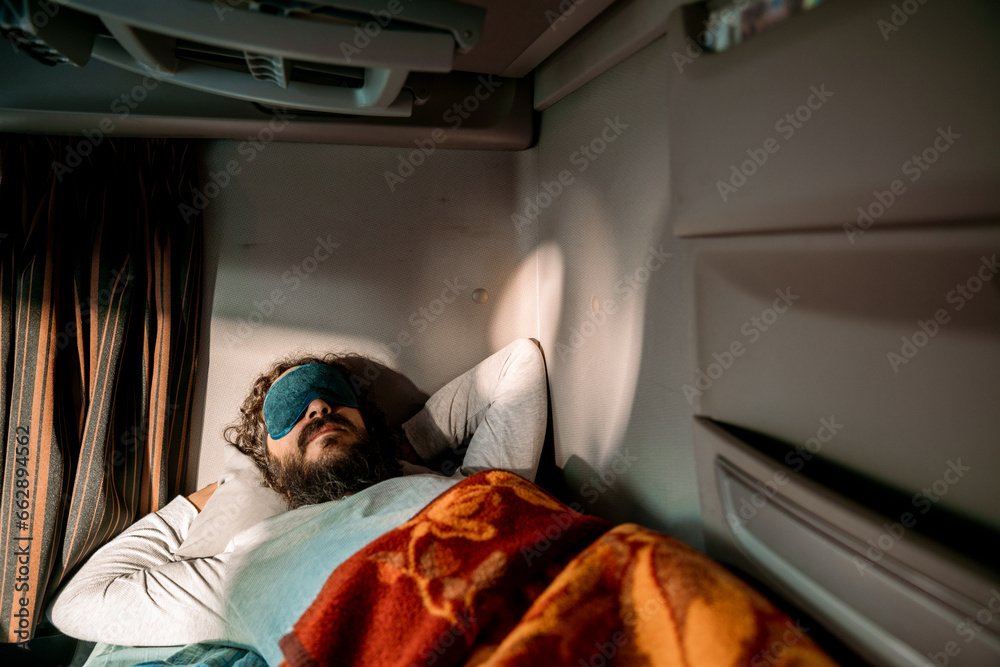 Young truck driver sleeping in his cabin after working long routes ...