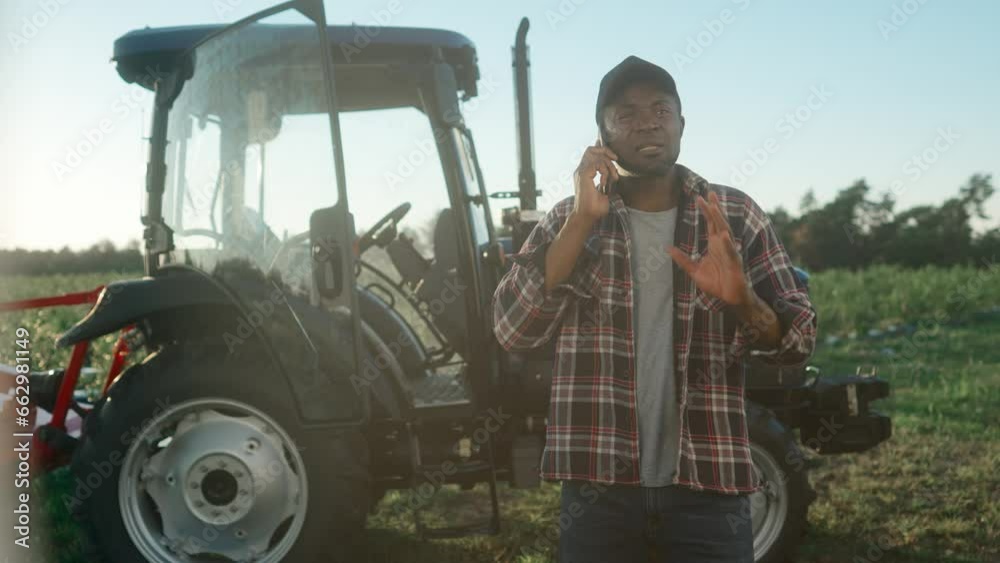 African American man arguing by phone. Angry farmland worker making ...