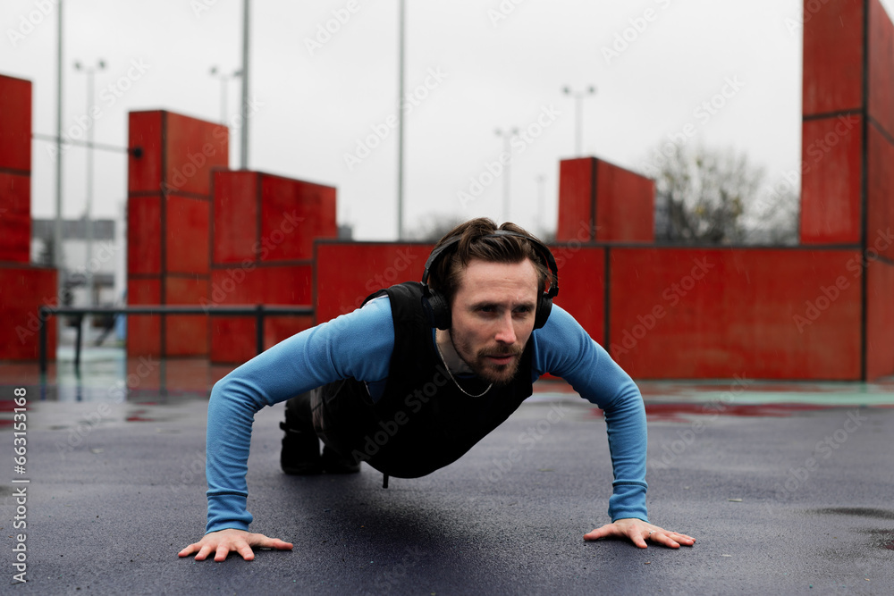 Strong young athlete doing pushups motion. Two hands on floor training ...