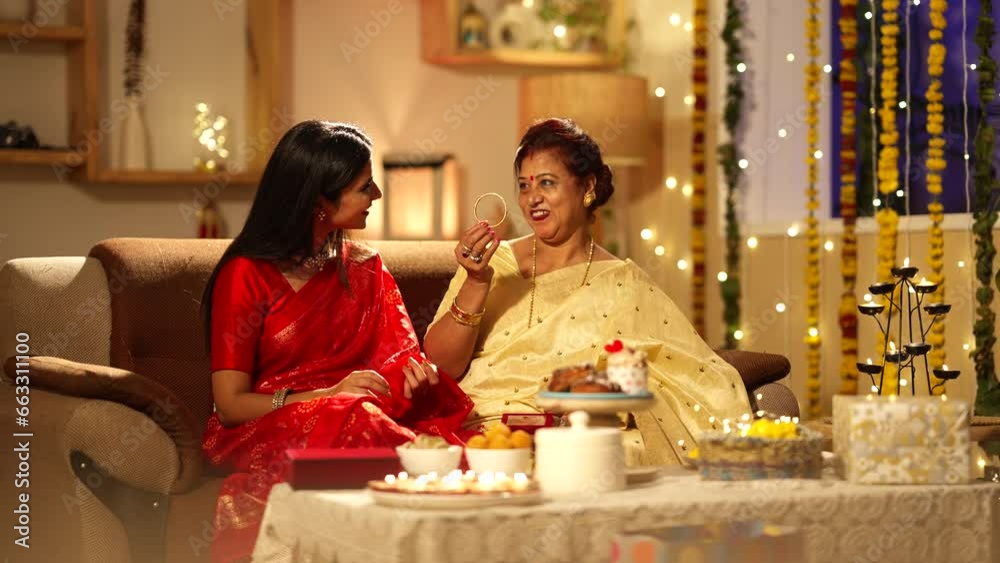 Beautiful Indian woman giving a gold bangle Diwali gift to her mother ...