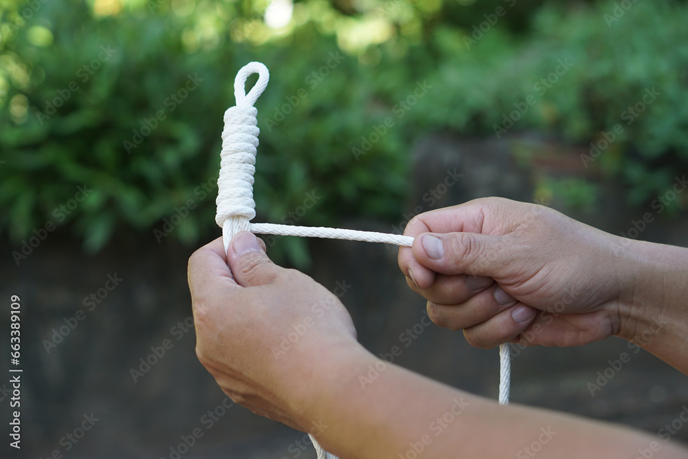 Close up hands tying white rope, Keeping long rope to be shorter ...