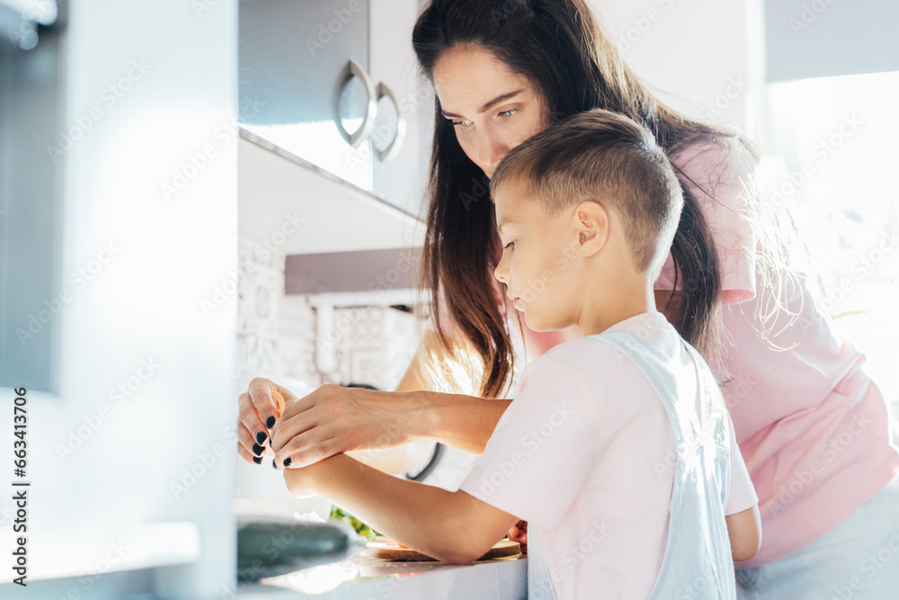 Caring young Mother putting a plaster on child finger with wound on ...