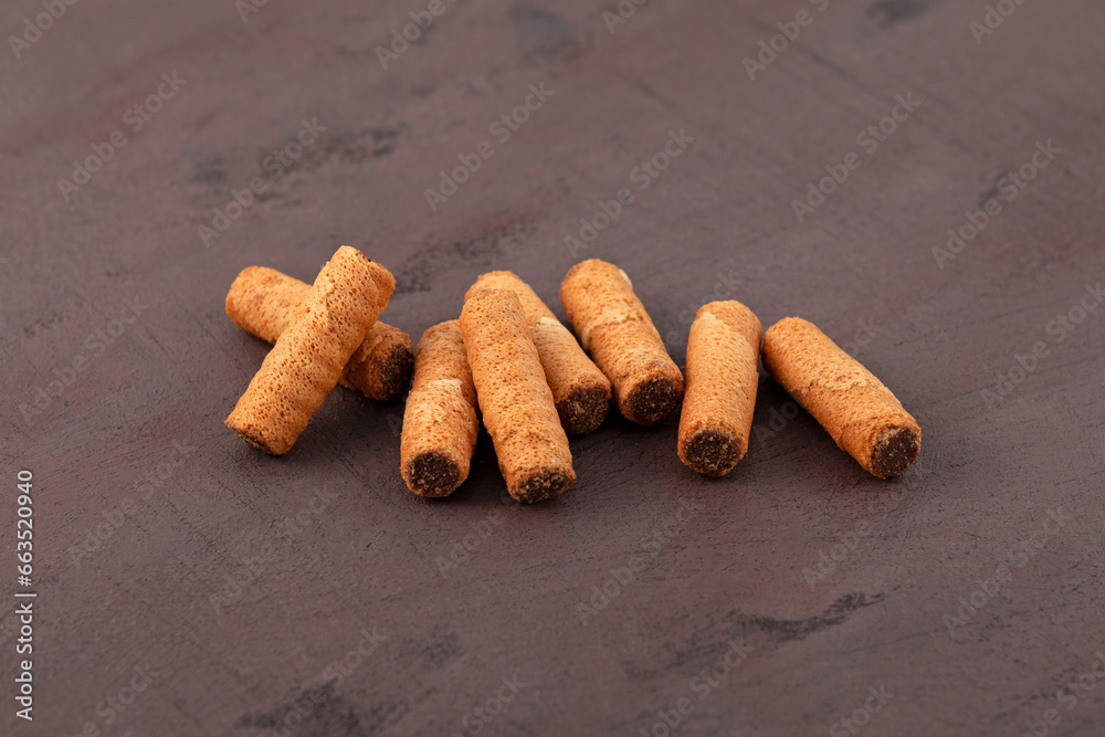 Waffle tubes with chocolate filling on brown background. Crispy wafer ...
