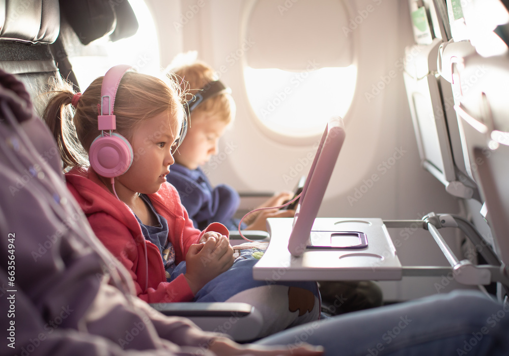 Adorable little boy girl travel by plane. Cute Kids sit at the window ...