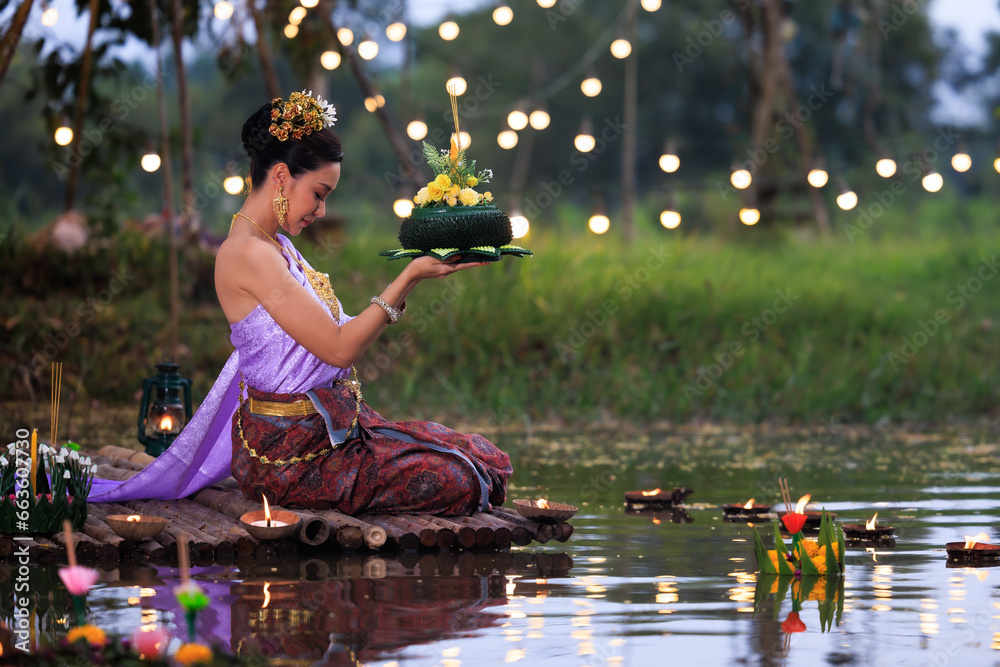 Loi Krathong Festival, Thai woman holding a krathong sitting on a raft ...