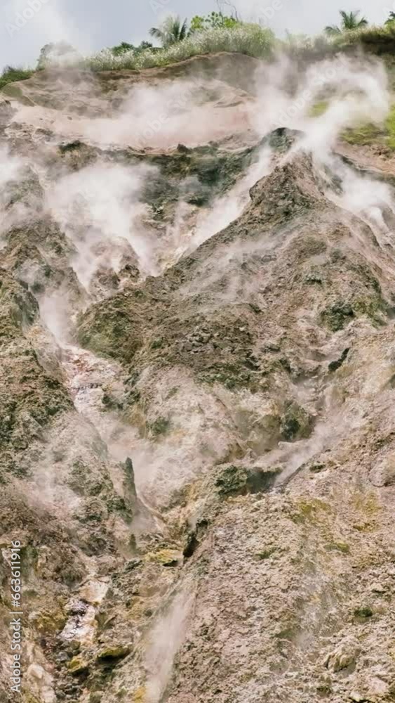 Volcanic activity on a mountainside with smoke and escaping gases. Slow ...