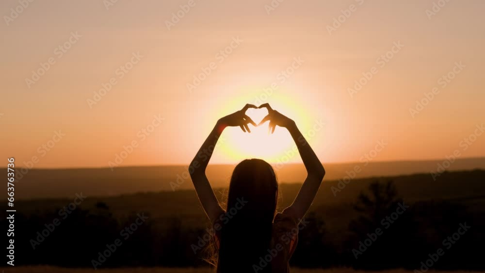 Happy girl in park at sunset. Finger-shaped heart shape. Hands of girl ...