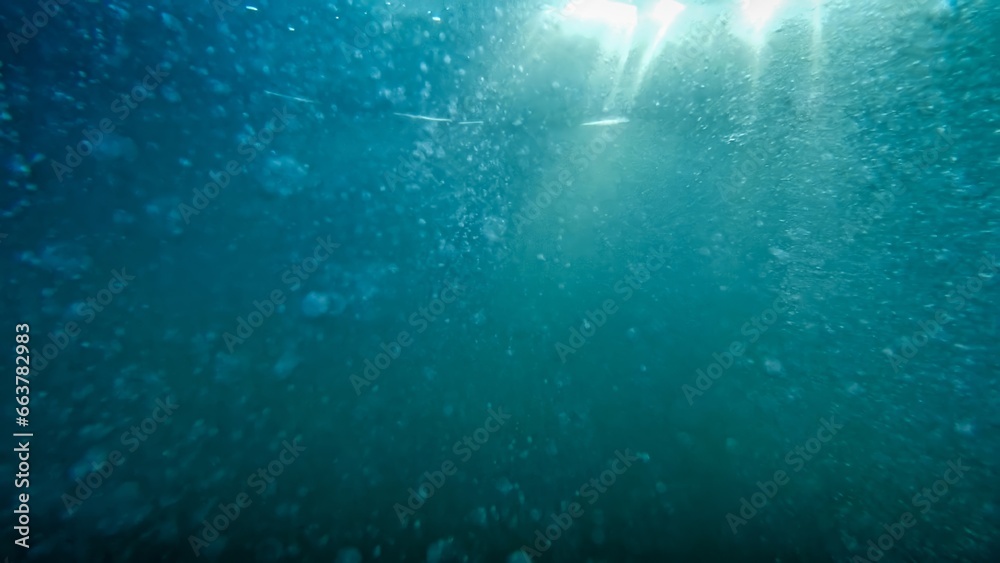 Air bubbles rising up from the ocean floor to the water surface, with ...