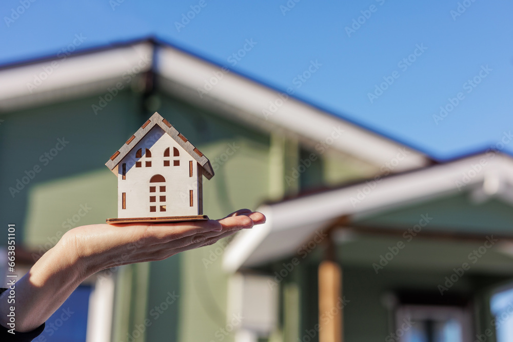 woman holds key and model of mock-up house in her hands. sale of real ...
