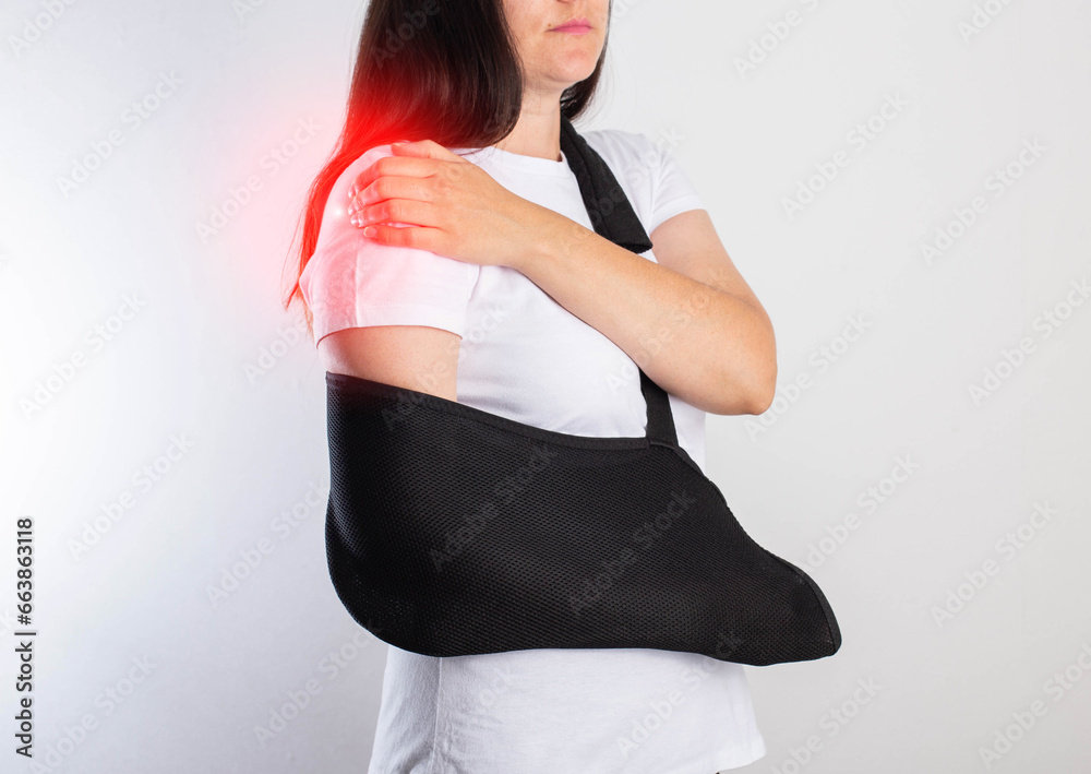 A girl on a white background with a black supporting medical bandage ...