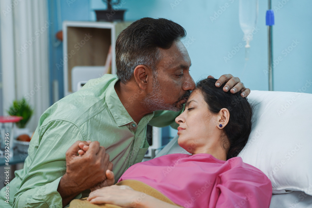 loving supportive husband comforts his wife during her hospital stay by ...
